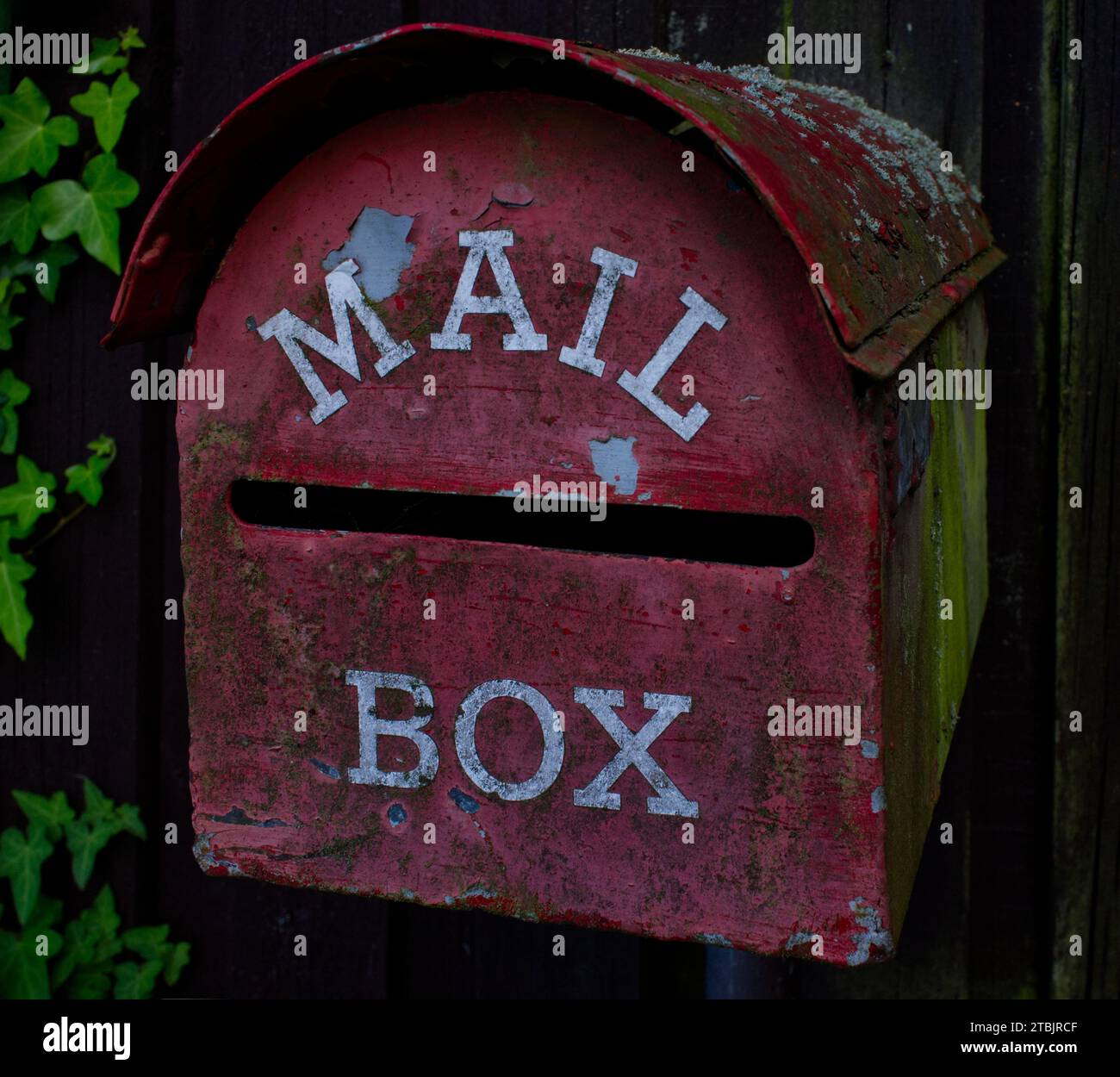 Red old and fairly weathered tin mailbox with lettering "mailbox" in ...
