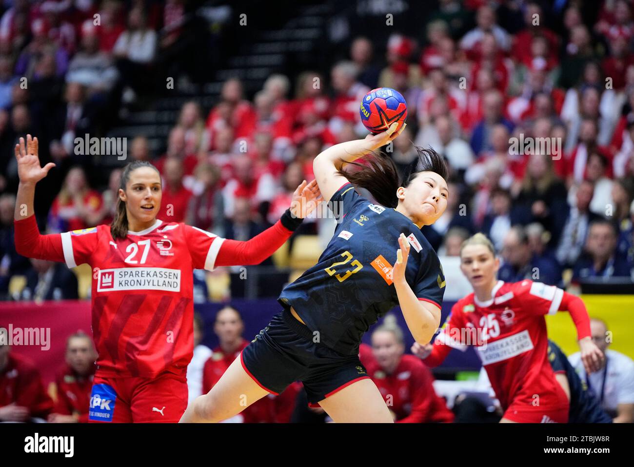 Japans Natsuki Aizawa shoots in front of Denmarks Louise Burgaard during the IHF World Womens ...