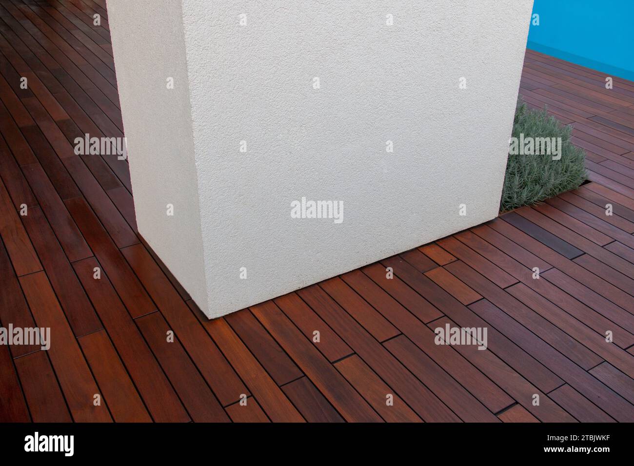 Contemporary plastered white concrete pillar on hardwood terrace floor ...