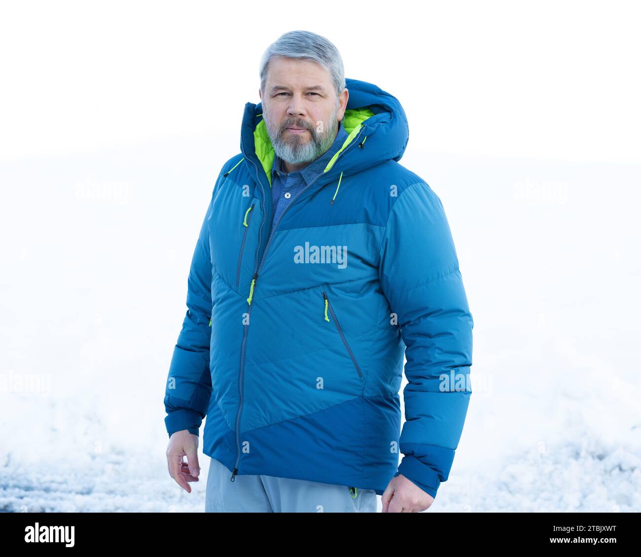 Man, 56 years, grey hair and beard, standing outside in winter with ...