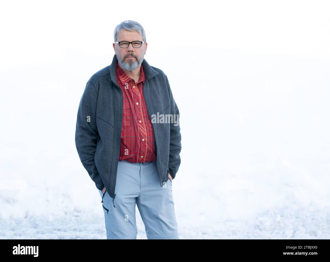 Man, 56 years, grey hair and beard, standing outside in winter with ...