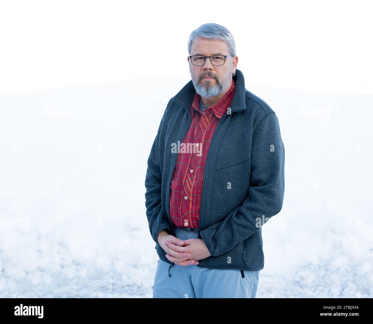 Man, 56 years, grey hair and beard, standing outside in winter with ...