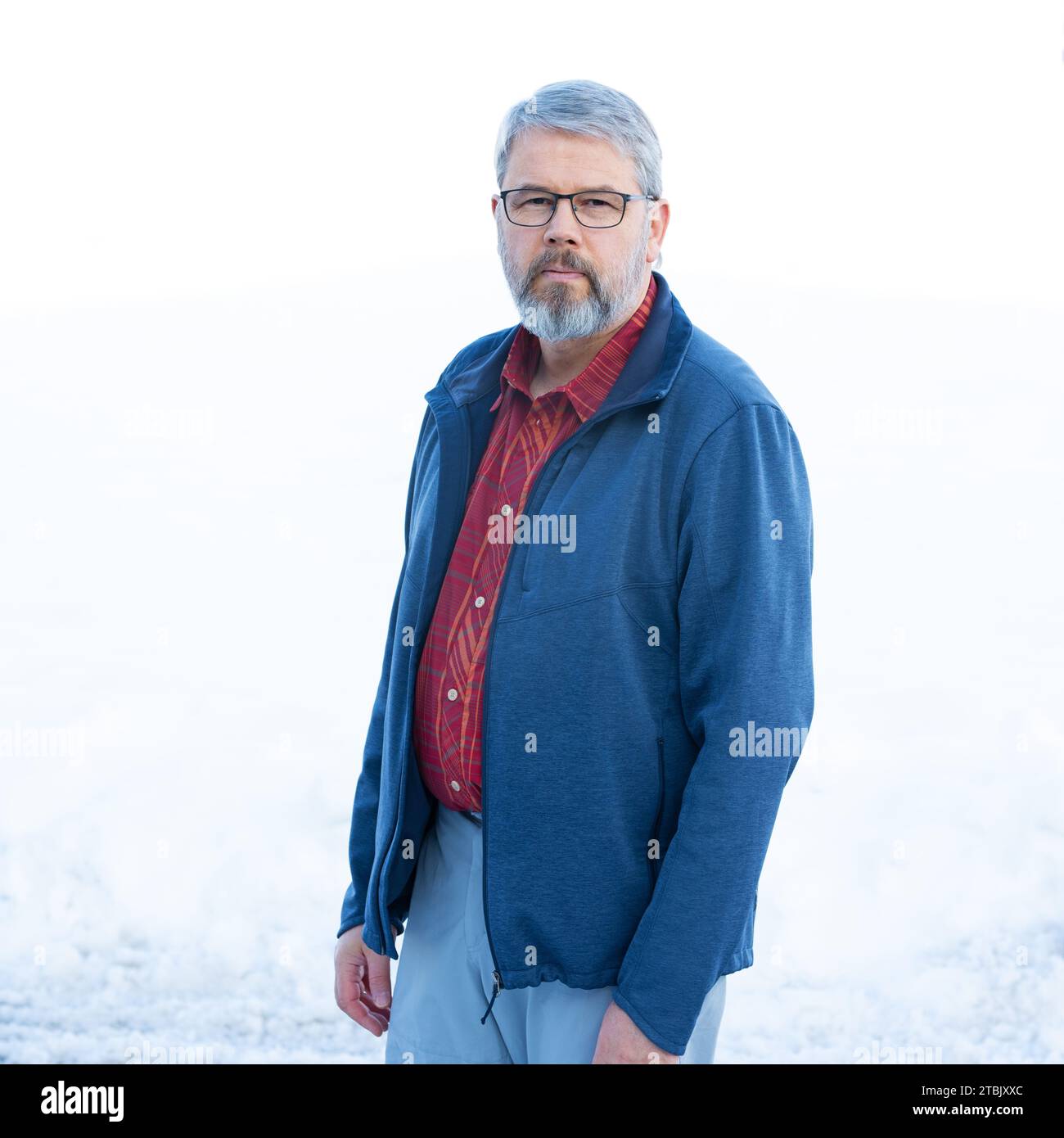 Man, 56 years, grey hair and beard, standing outside in winter with ...