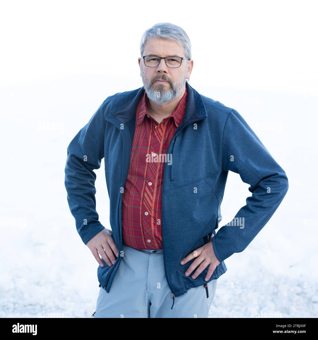 Man, 56 years, grey hair and beard, standing outside in winter with ...