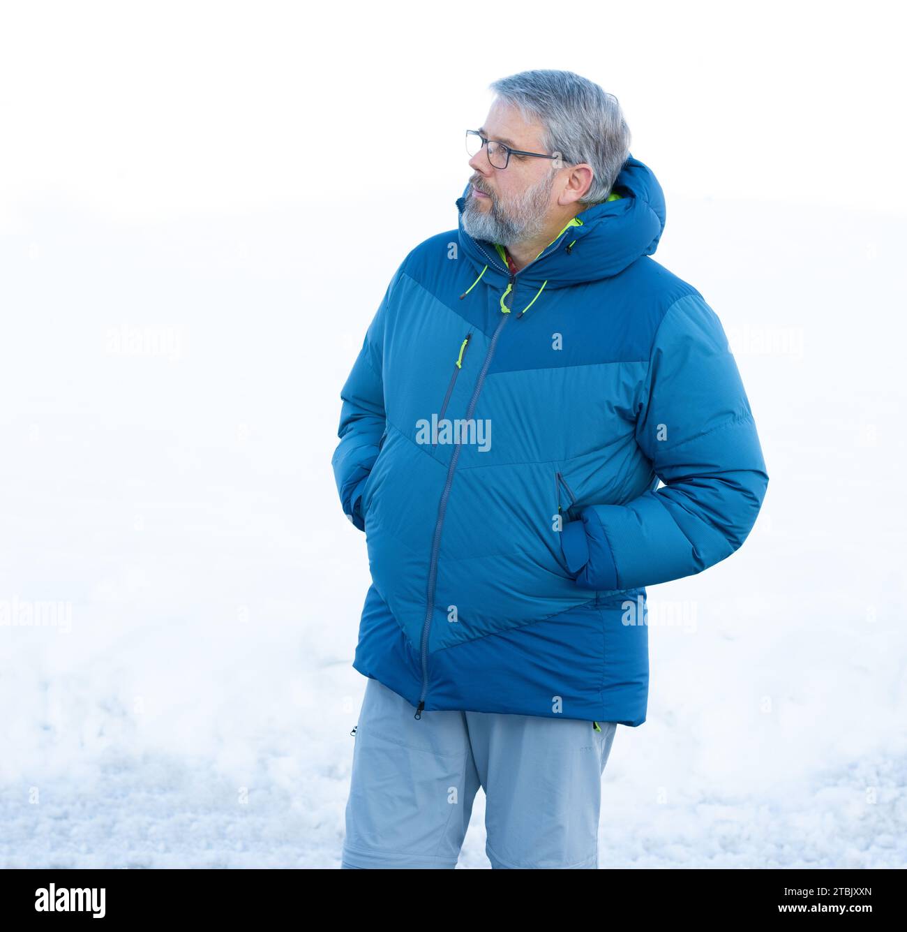 Man, 56 years, grey hair and beard, standing outside in winter with ...