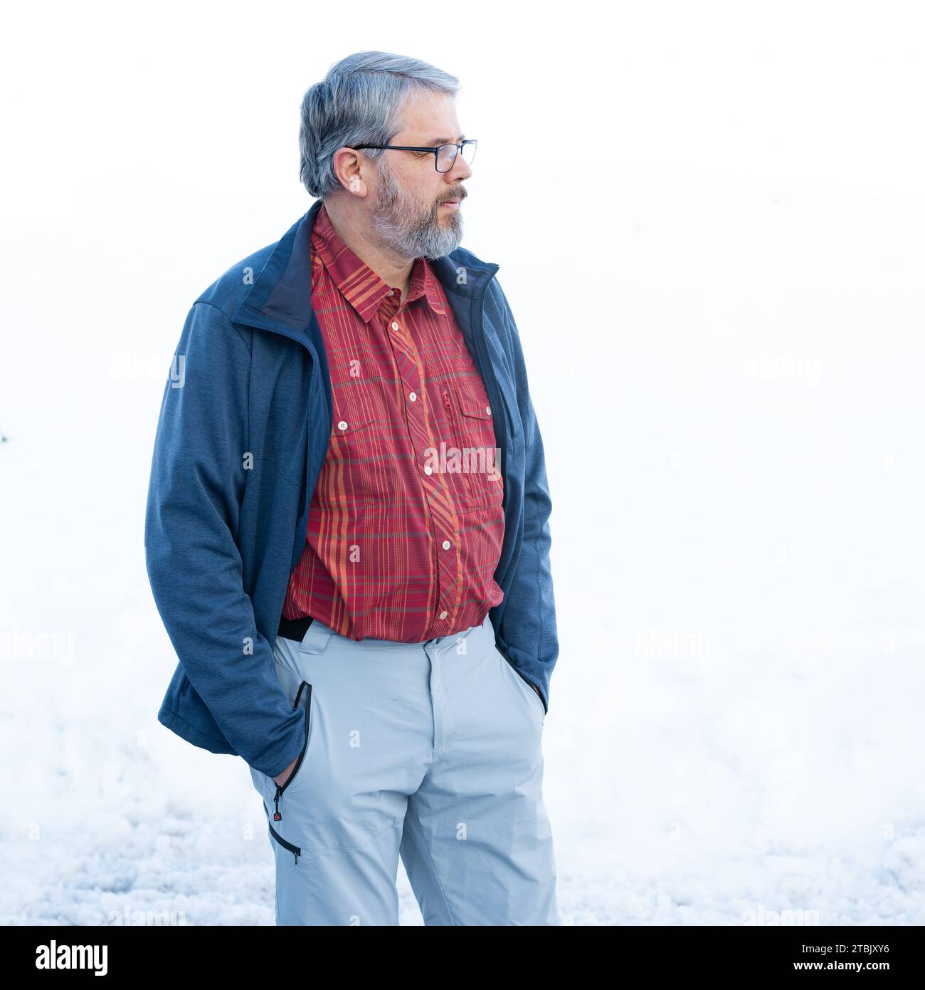 Man, 56 years, grey hair and beard, standing outside in winter with ...