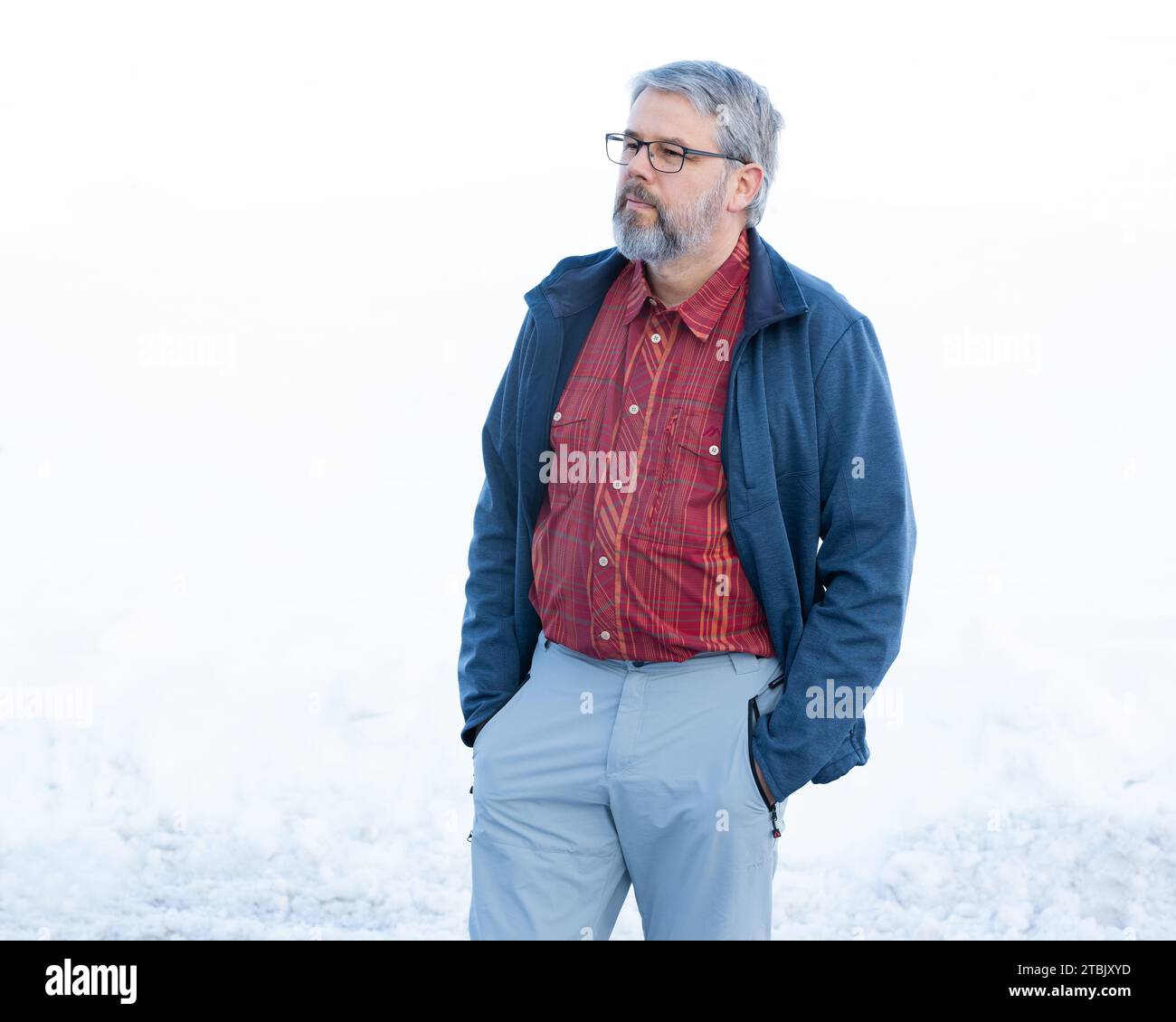 Man, 56 years, grey hair and beard, standing outside in winter with ...