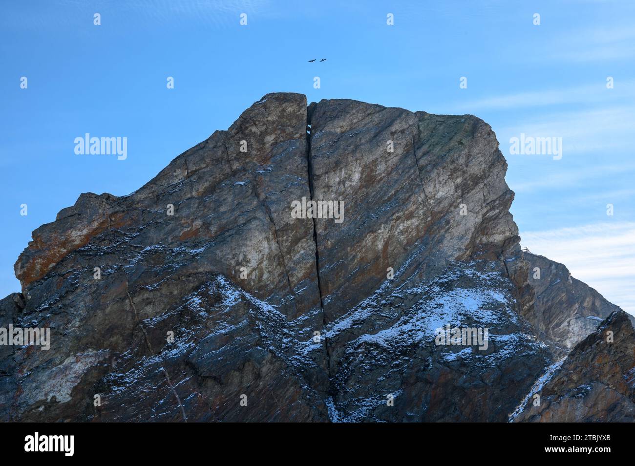 two birds fly over a cracked rock. Beautiful winter landscape of frozen ...