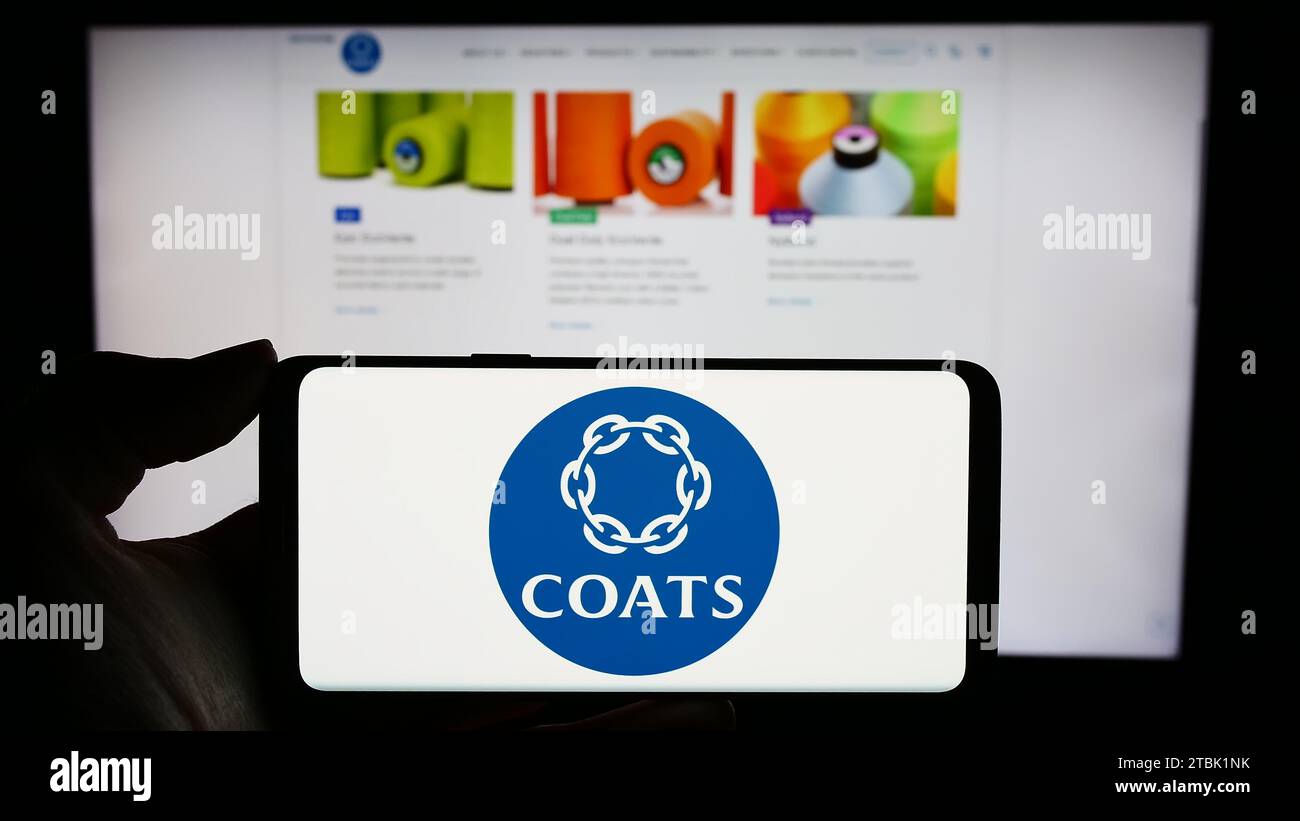 Person holding cellphone with logo of British textile material company ...