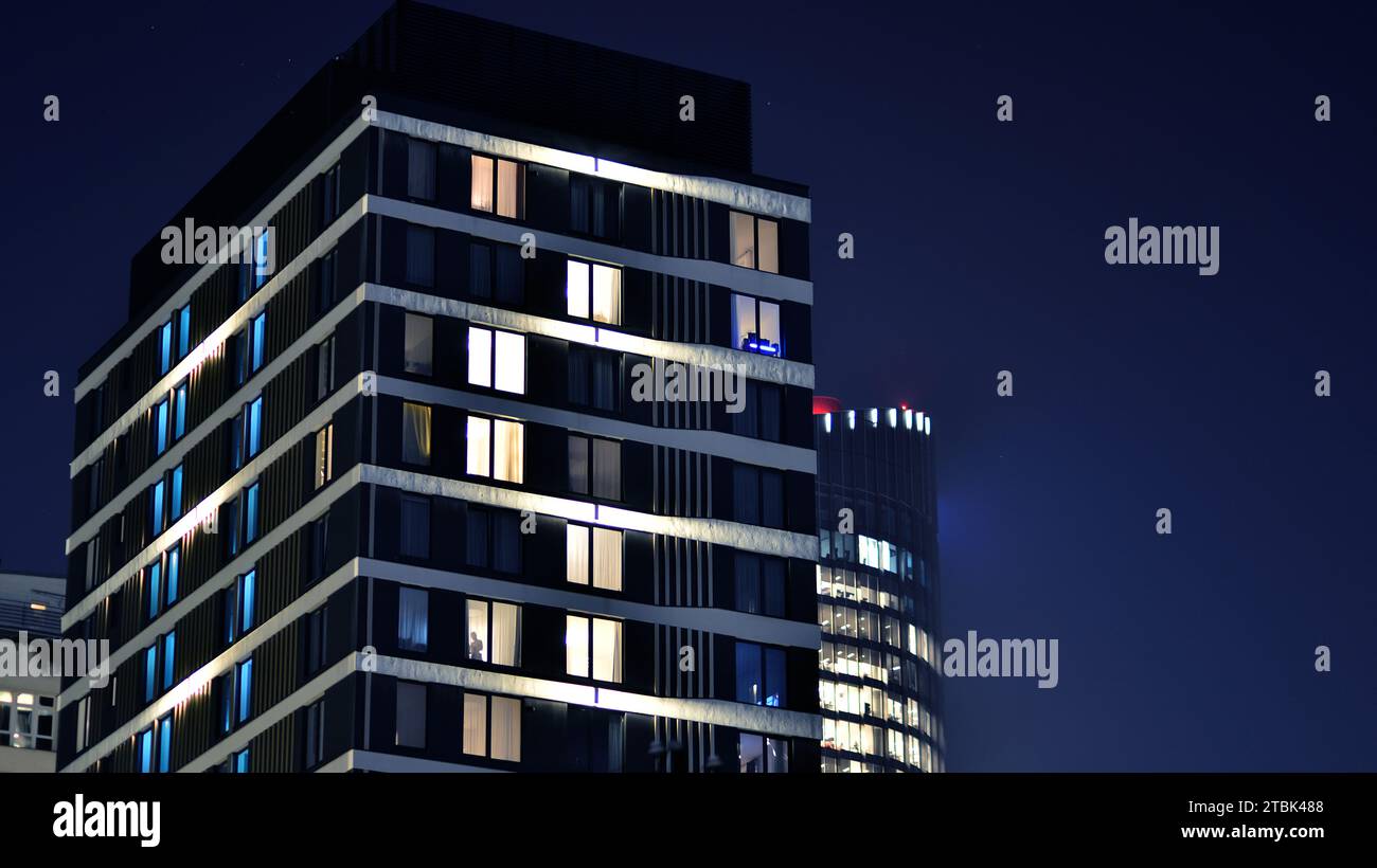 Glowing windows of the multi-storey building in night. View of modern ...