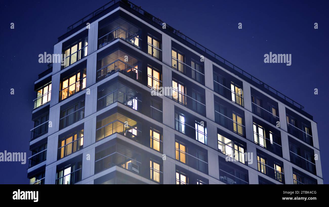 Glowing windows of the multi-storey building in night. View of modern ...