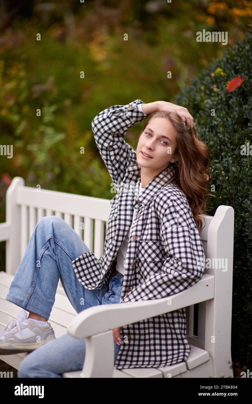 Charming Autumn Casual: Beautiful Girl on Park Bench Stock Photo - Alamy