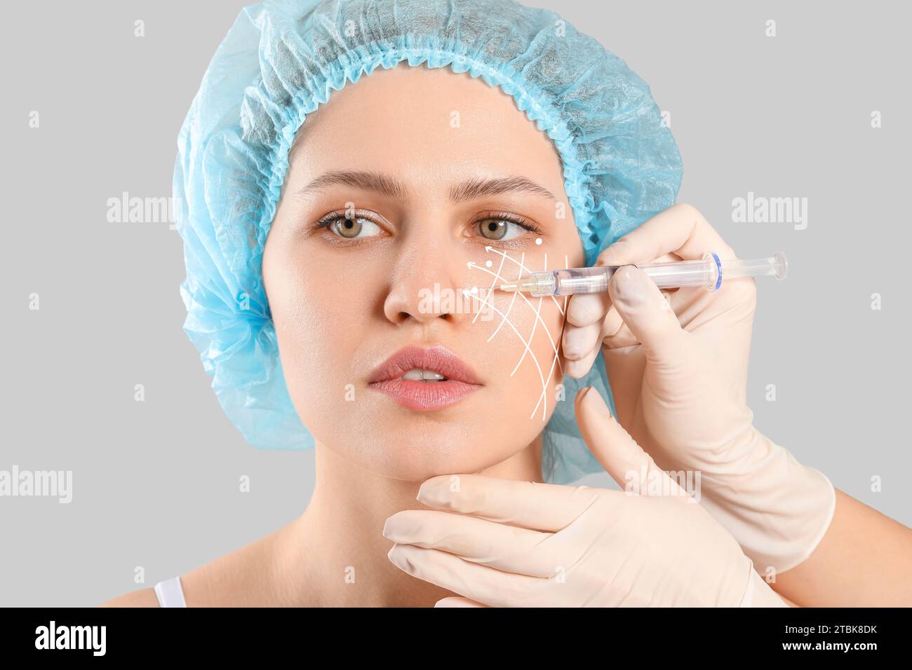 Young woman receiving filler injection on grey background. Skin care ...