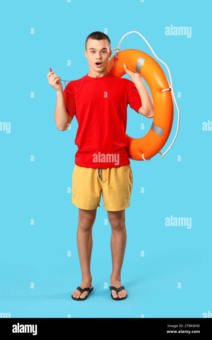 Shocked male lifeguard with ring buoy and whistle on blue background ...