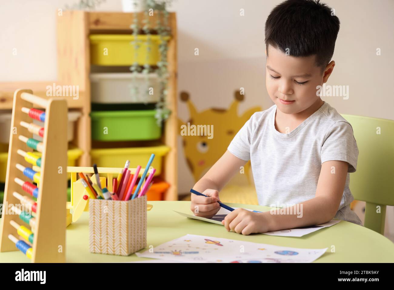 Little Asian boy drawing at home Stock Photo - Alamy