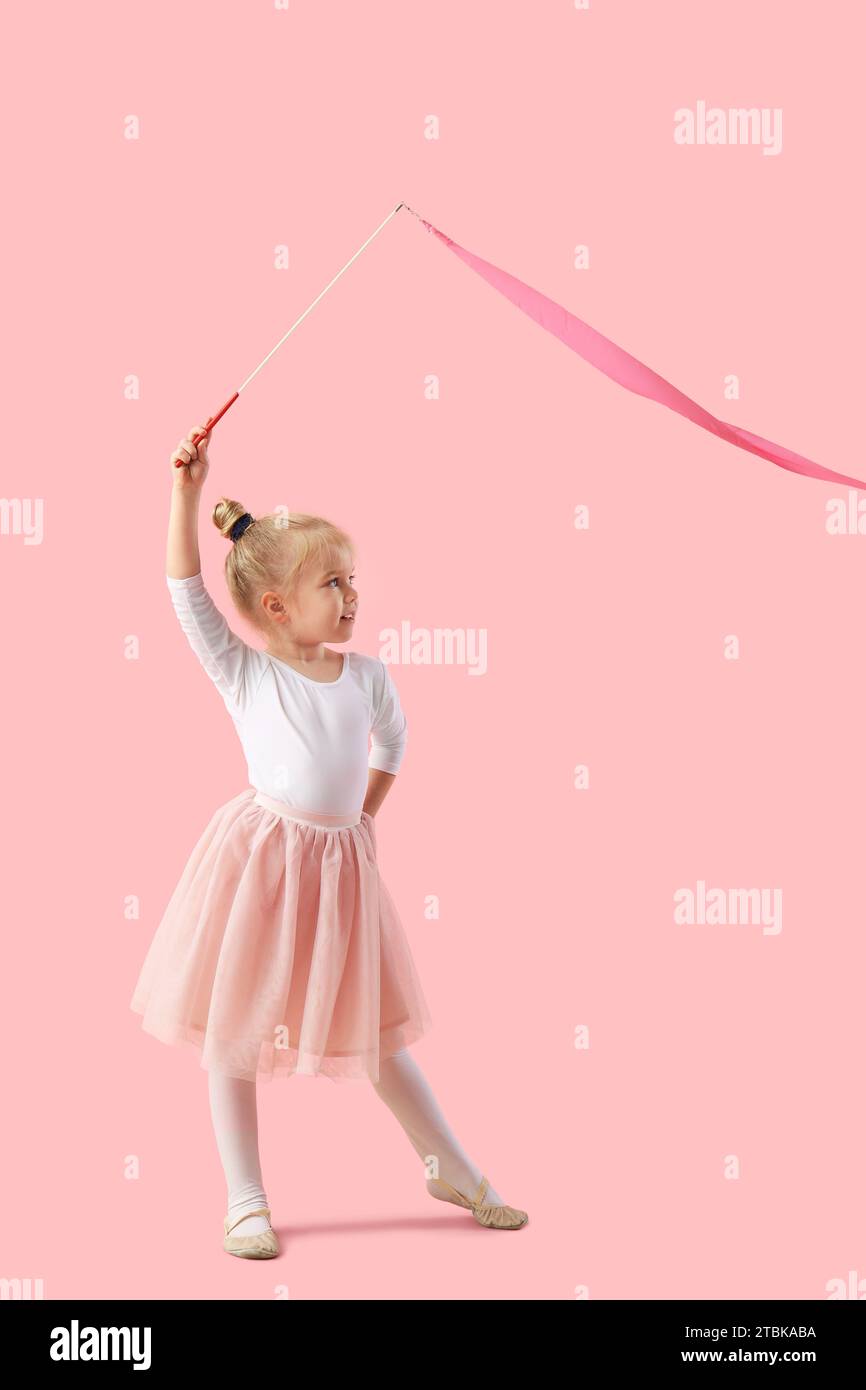 Cute little girl with ribbon doing gymnastics on pink background Stock ...