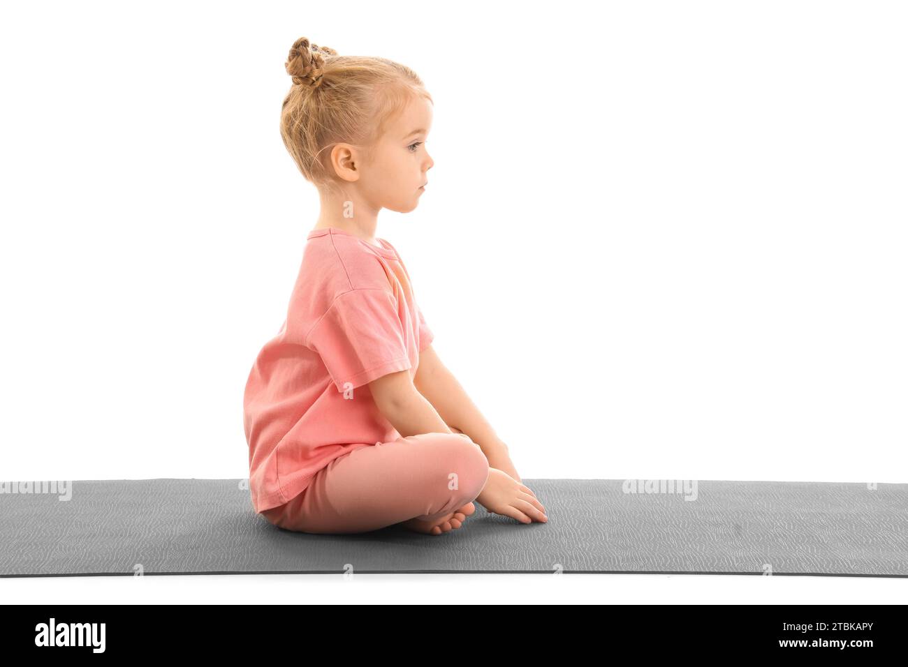 Cute little girl with mat practicing yoga isolated on white background ...