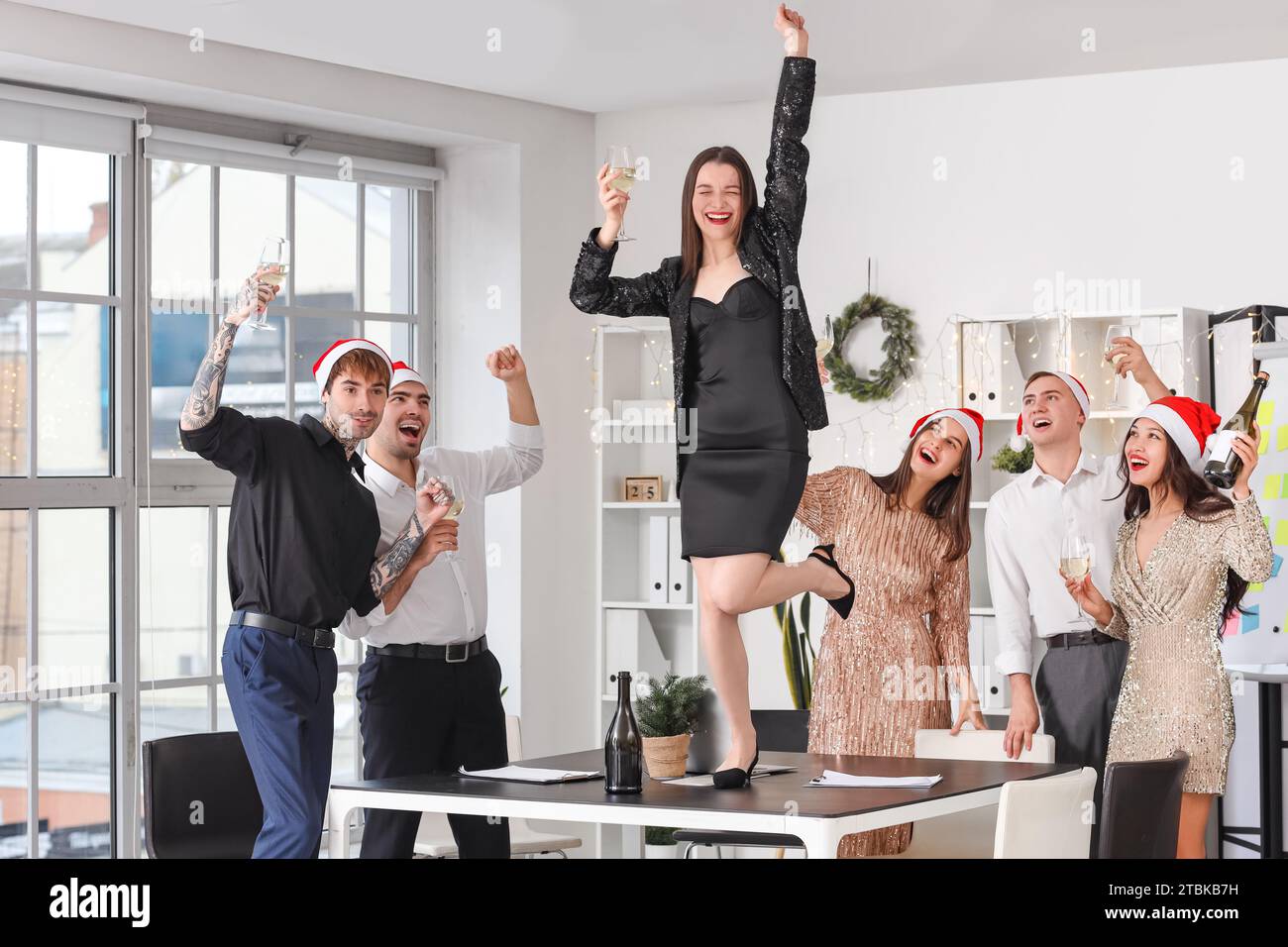 Young colleagues with champagne dancing at New Year party in office ...