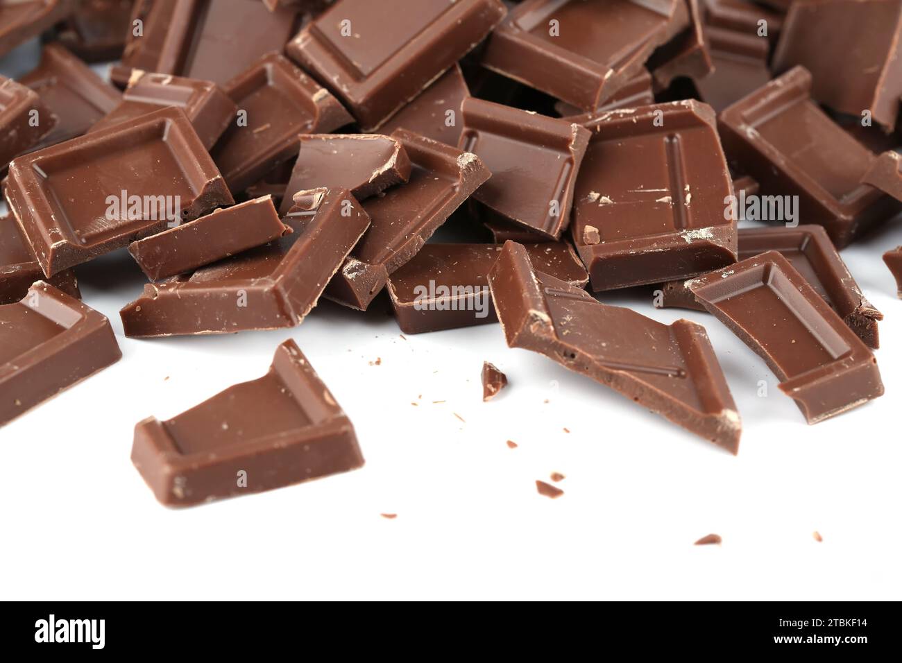 Heap of chocolate chunks on white background Stock Photo - Alamy