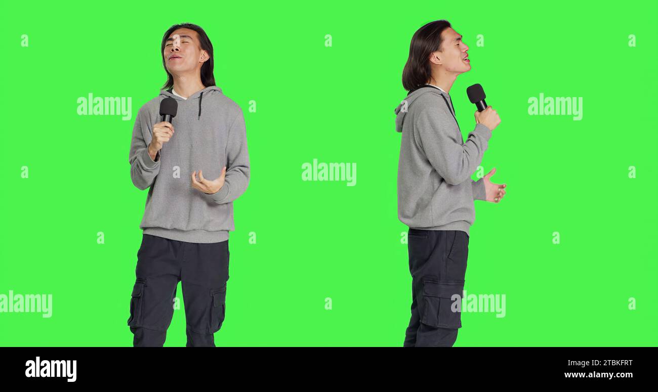 Trendy guy performs karaoke on camera, using recording device to sing ...