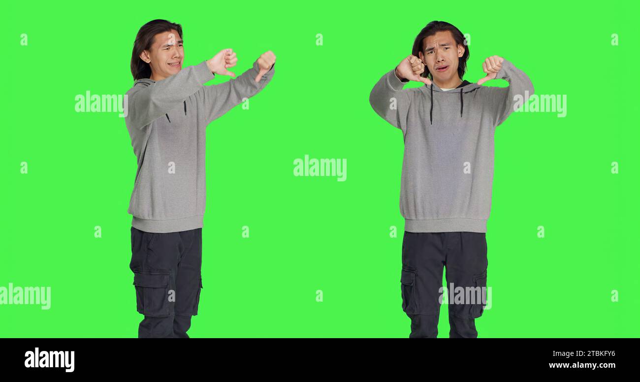 Asian person shows thumbs down sign and feeling disappointed in front ...