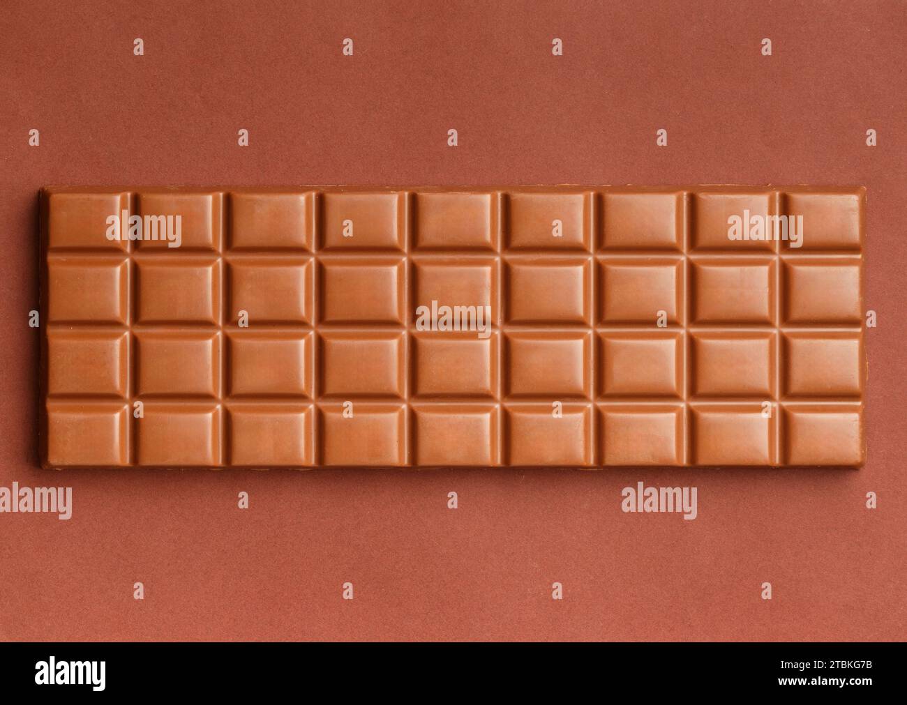 Large whole chocolate bar on brown background, top view. Milk chocolate ...