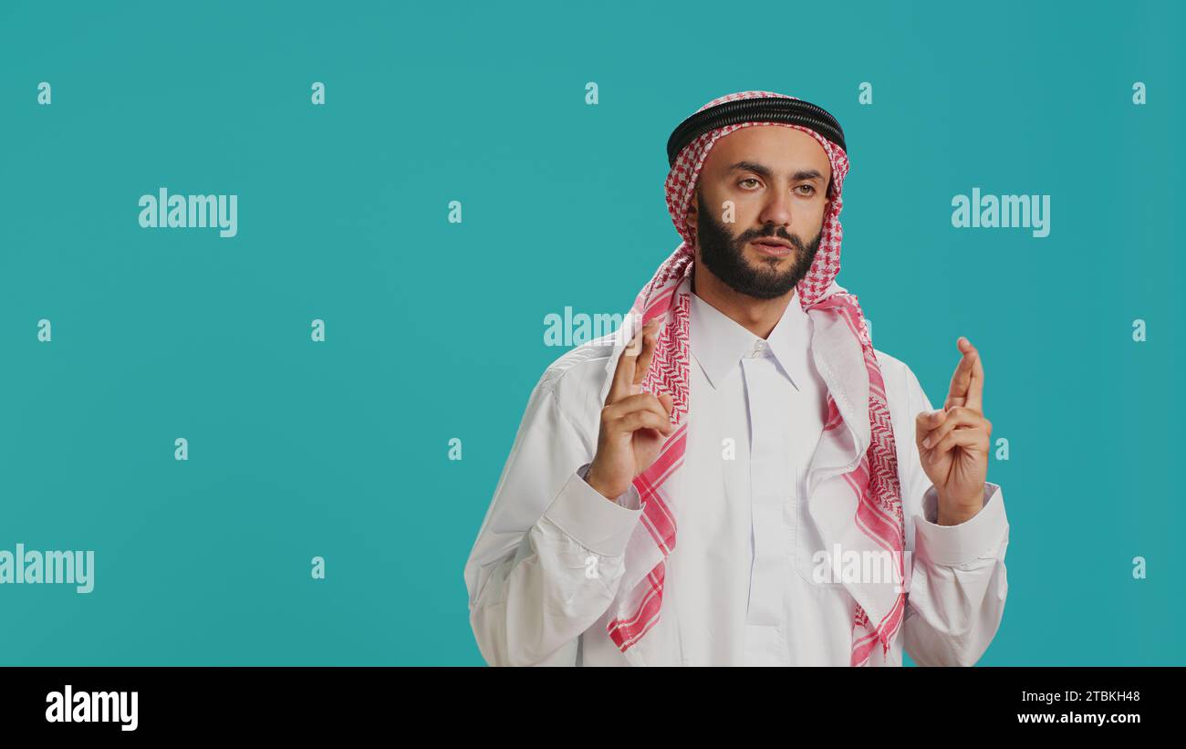Muslim man holds fingers crossed and praying to allah over blue ...