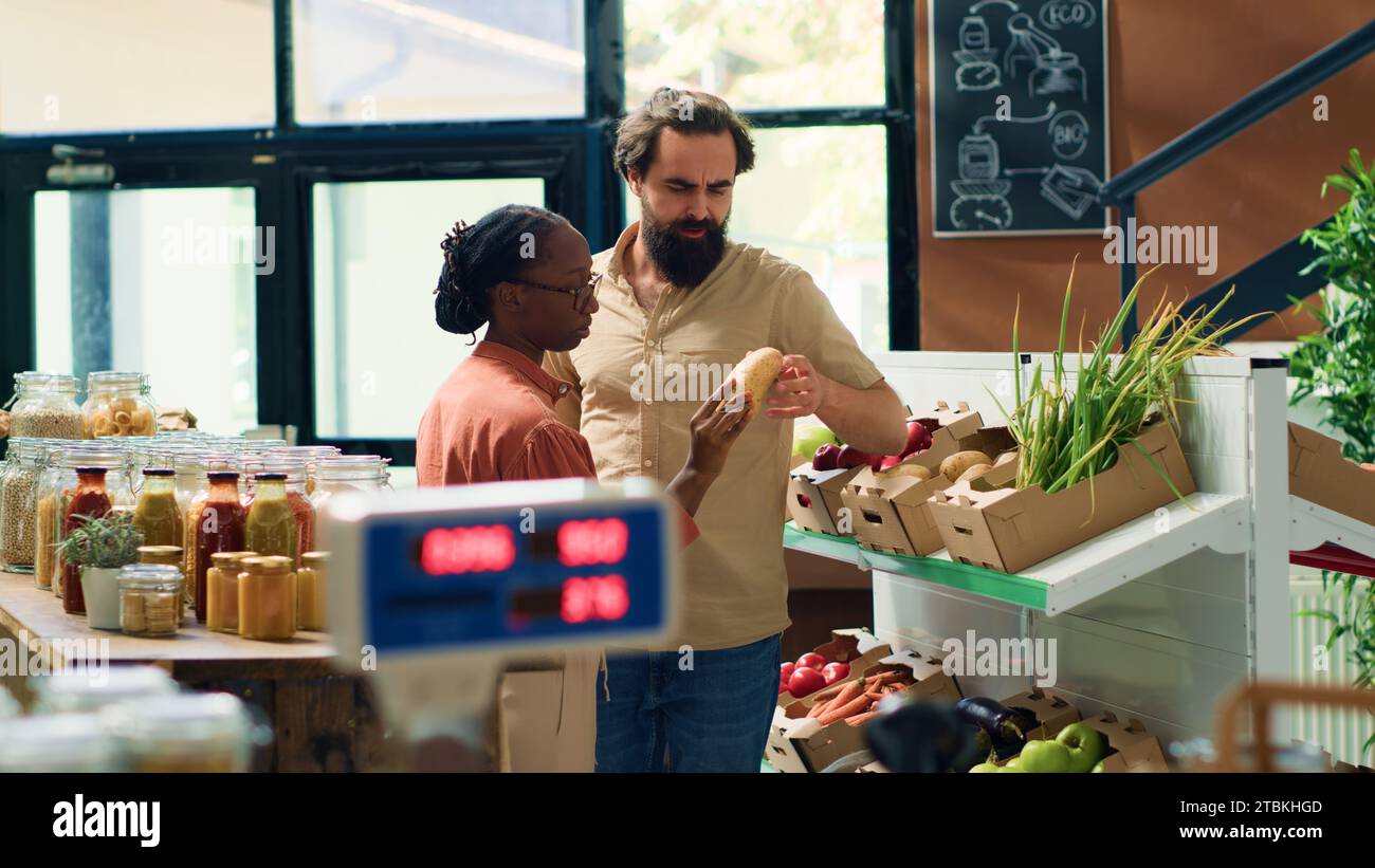 Couple asking owner about products in organic bio supermarket ...