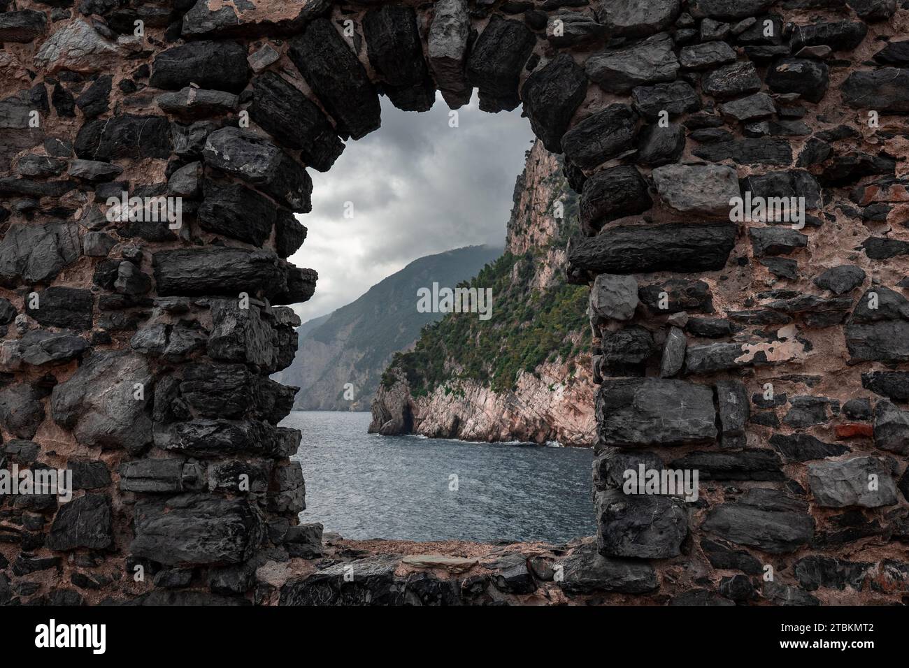 Arched stone window or opening in a stone wall overlooking scenic ...