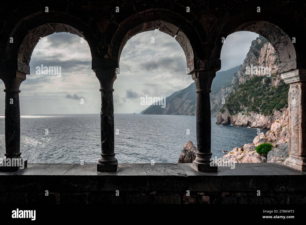 Arched stone window or opening in a stone wall overlooking scenic ...