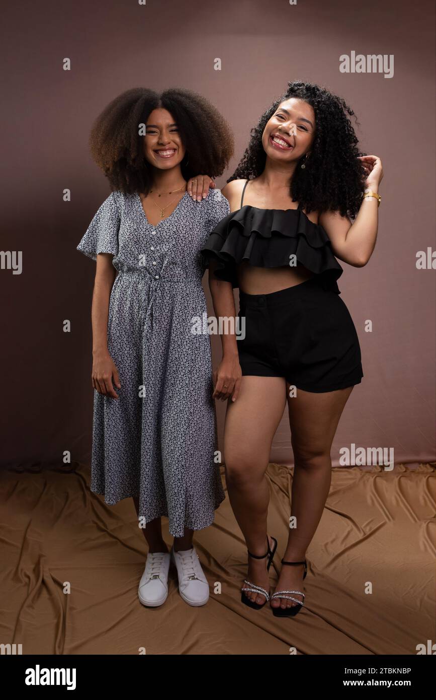 Two women together, young friends, smiling, posing for a photo ...