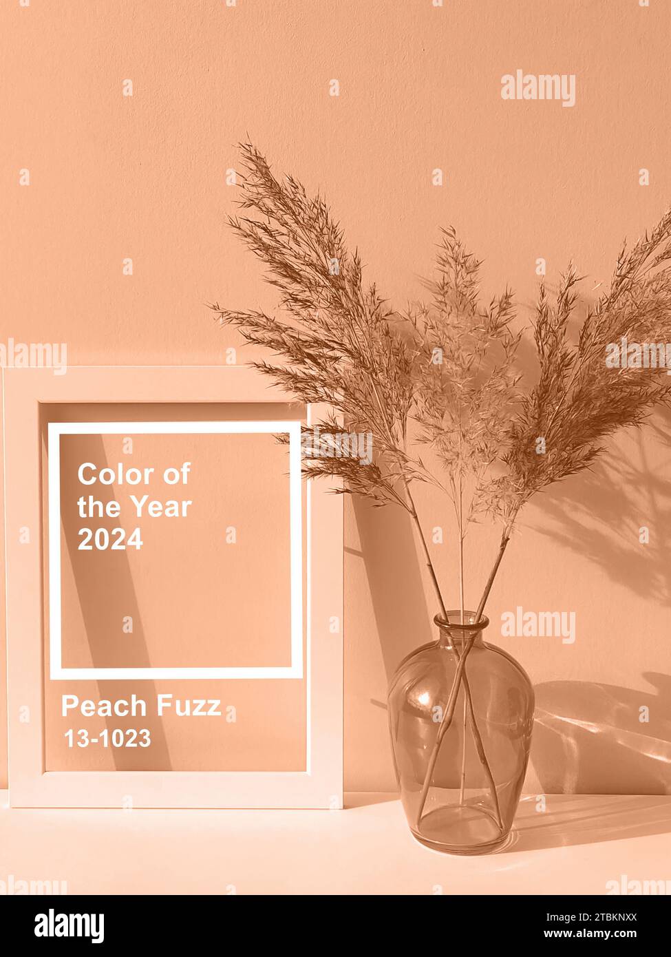 Peach fuzz is the color of the year 2024. Frame, glass vase and dry ...