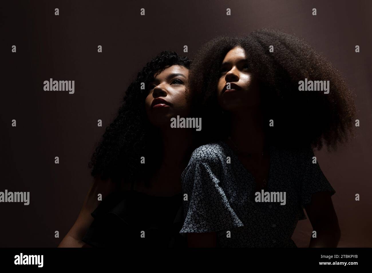 Half-closed photo of two pretty young friends, together, in low light ...