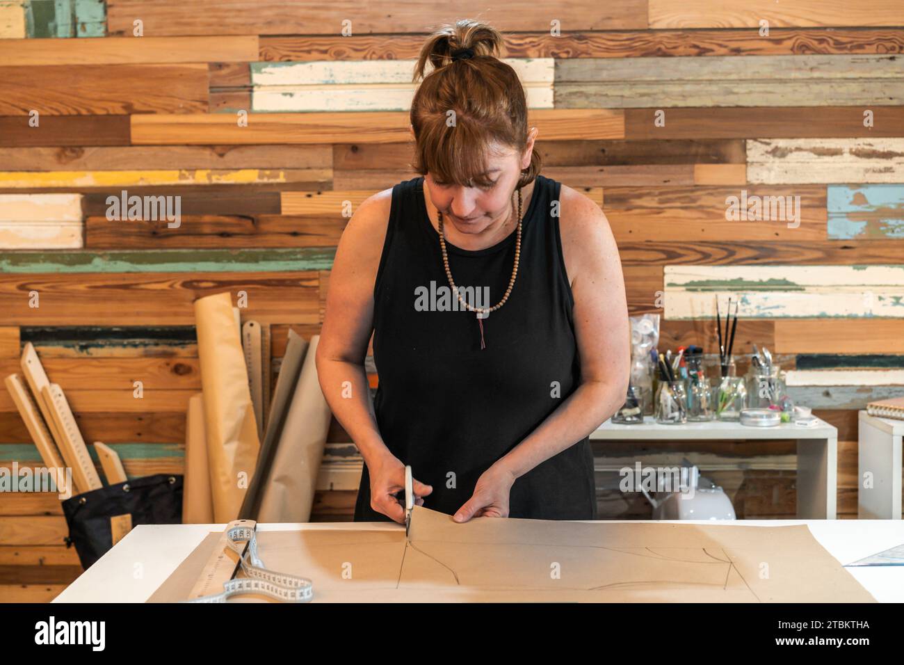 Fashion designer cutting clothes patterns at her studio Stock Photo - Alamy