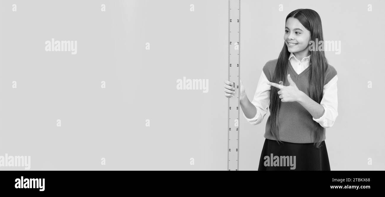 cheerful teen girl study math pointing finger on ruler measuring size ...