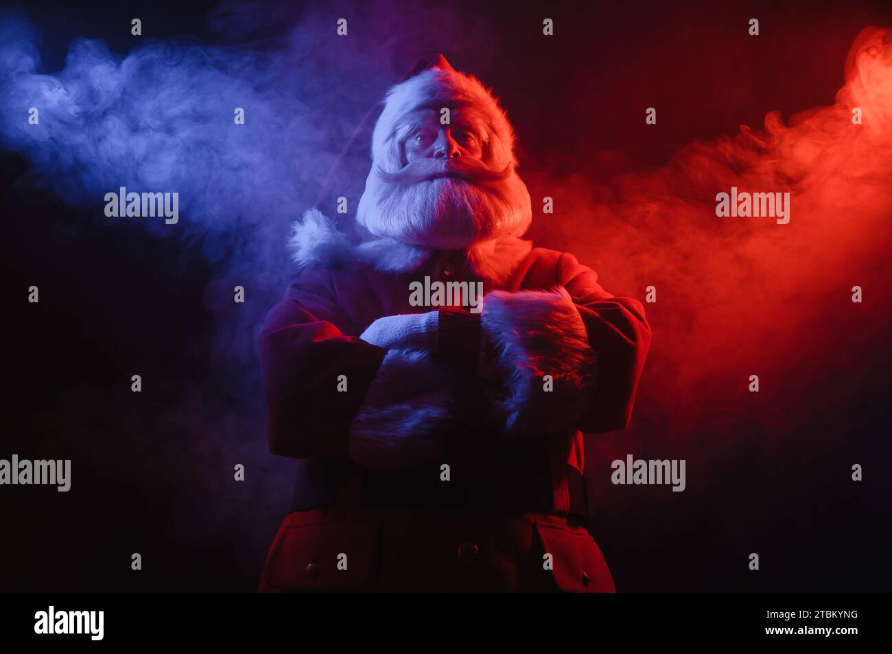 Santa Claus stands with his arms crossed on his chest in blue red neon ...