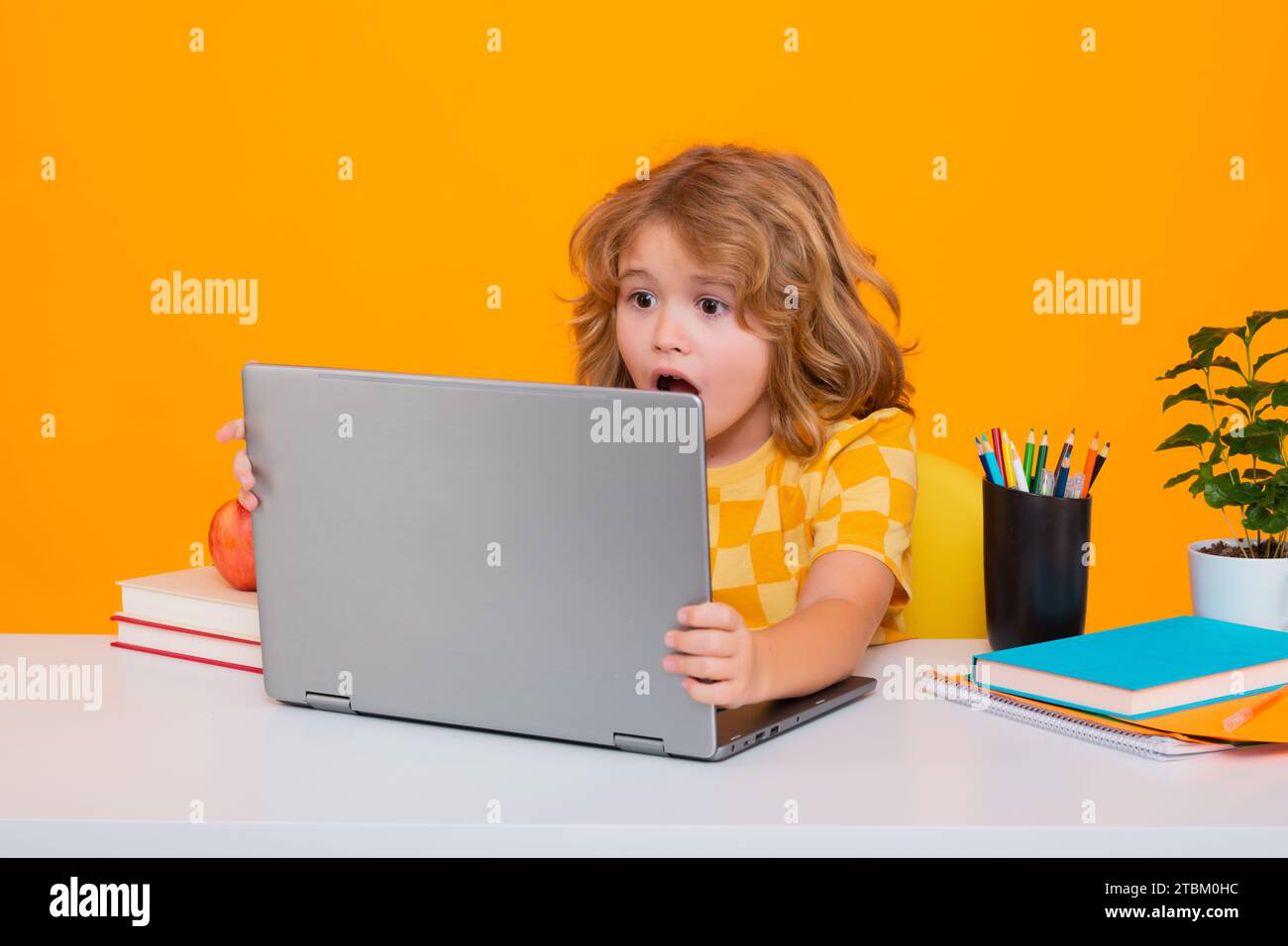 Excited school child using laptop computer. School child portrait ...