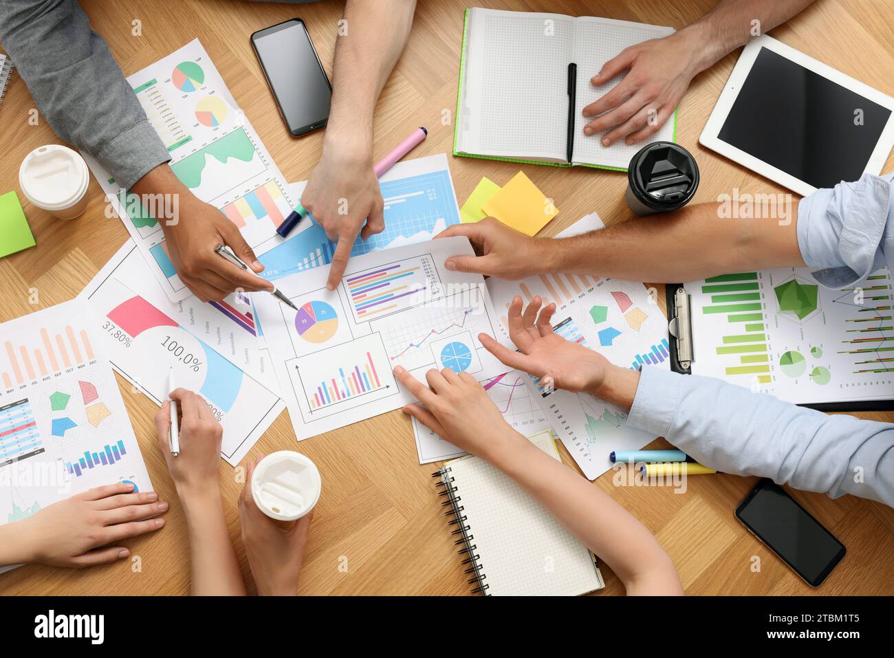 Team of employees working together at wooden table, top view. Startup ...