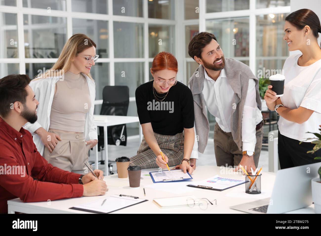 Team of employees working together in office Stock Photo - Alamy