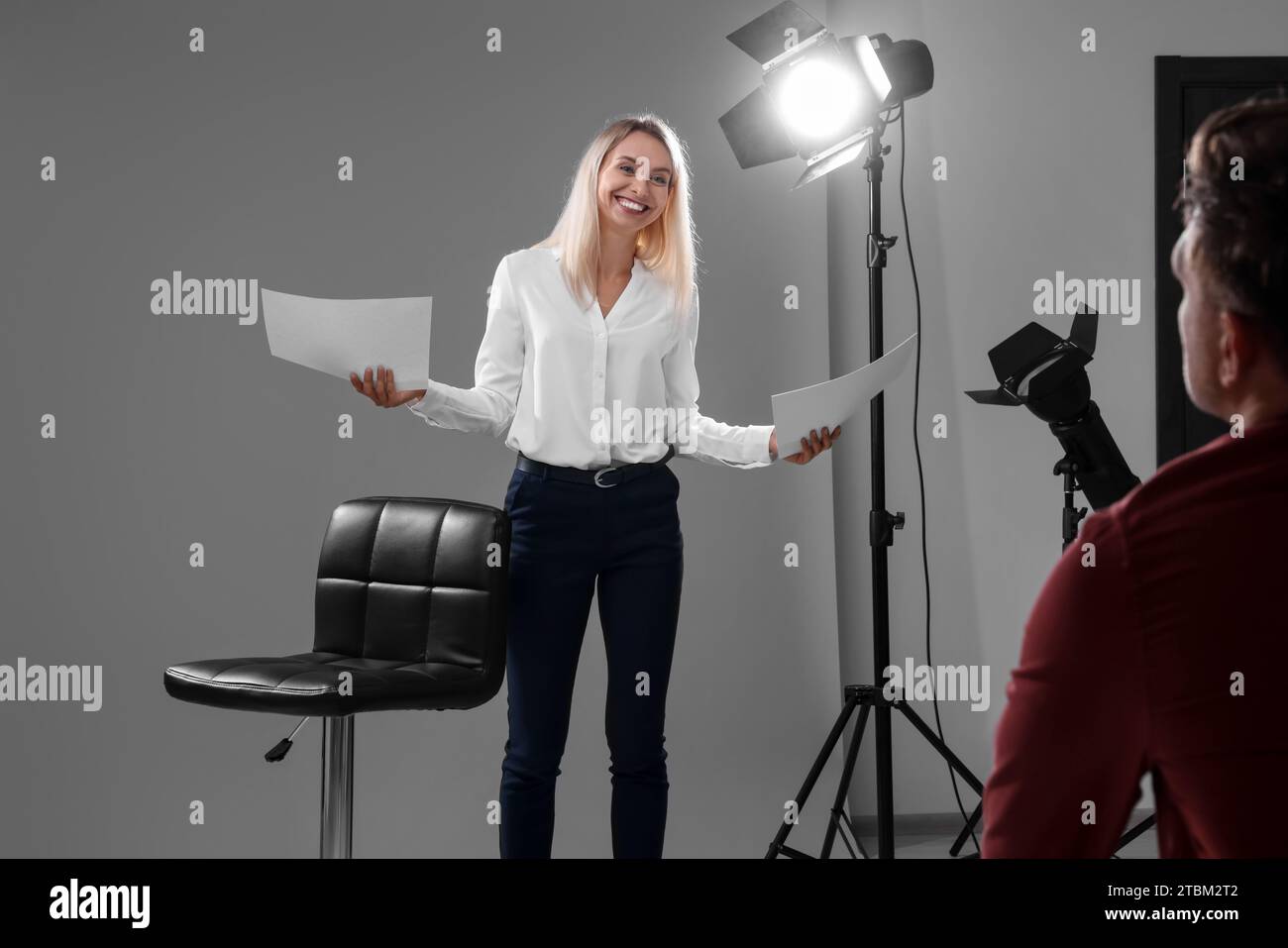 Emotional woman with script performing in front of casting director ...