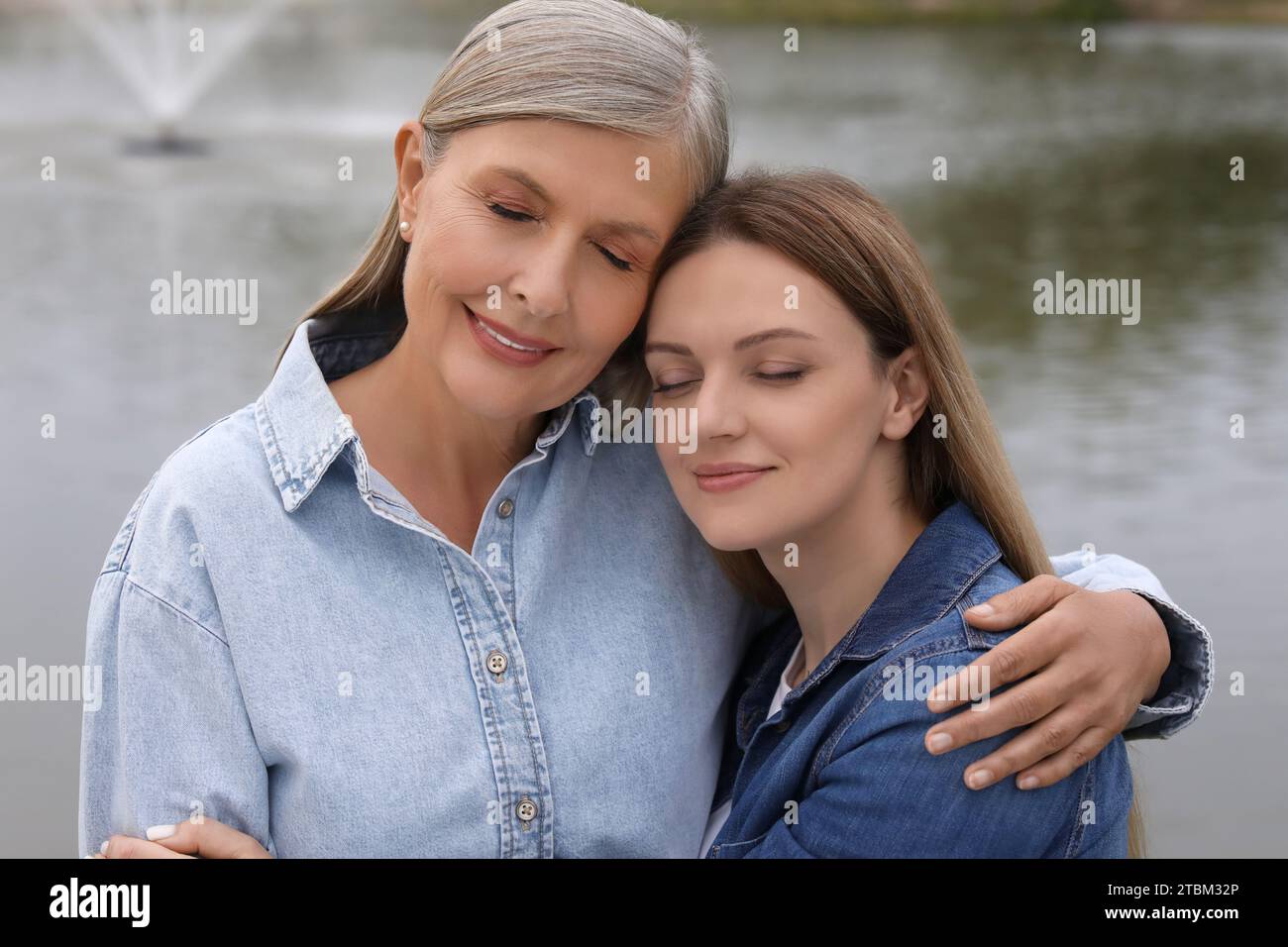 Happy mature mother and her daughter near pond Stock Photo - Alamy