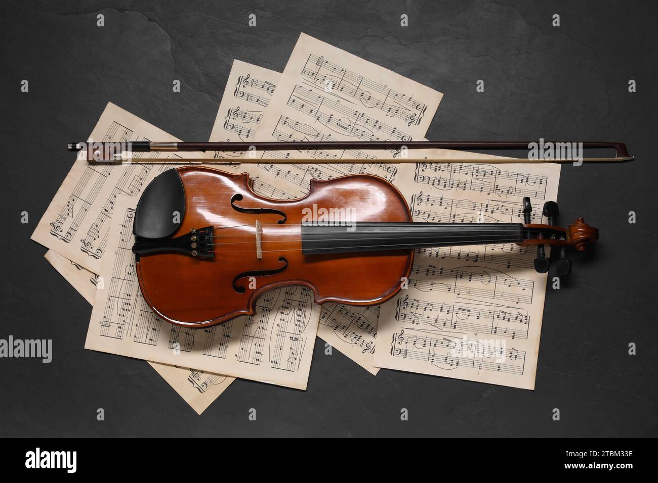Violin, bow and music sheets on black table, top view Stock Photo - Alamy