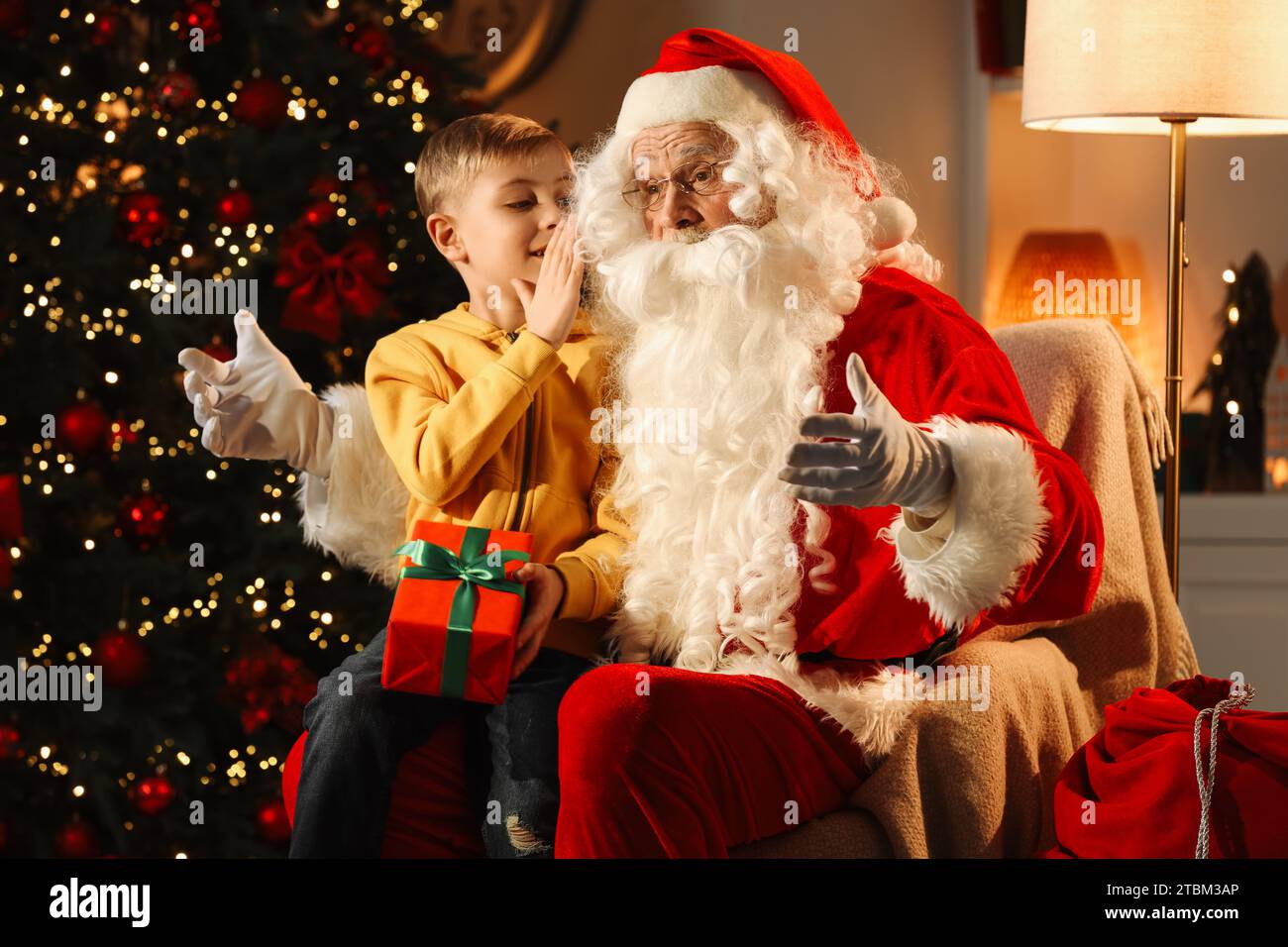 Merry Christmas. Little boy whispering his wish to Santa at home Stock ...