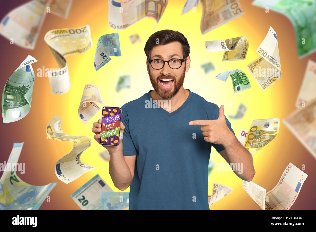 Your Bet Wins! Emotional man pointing at smartphone under money shower ...