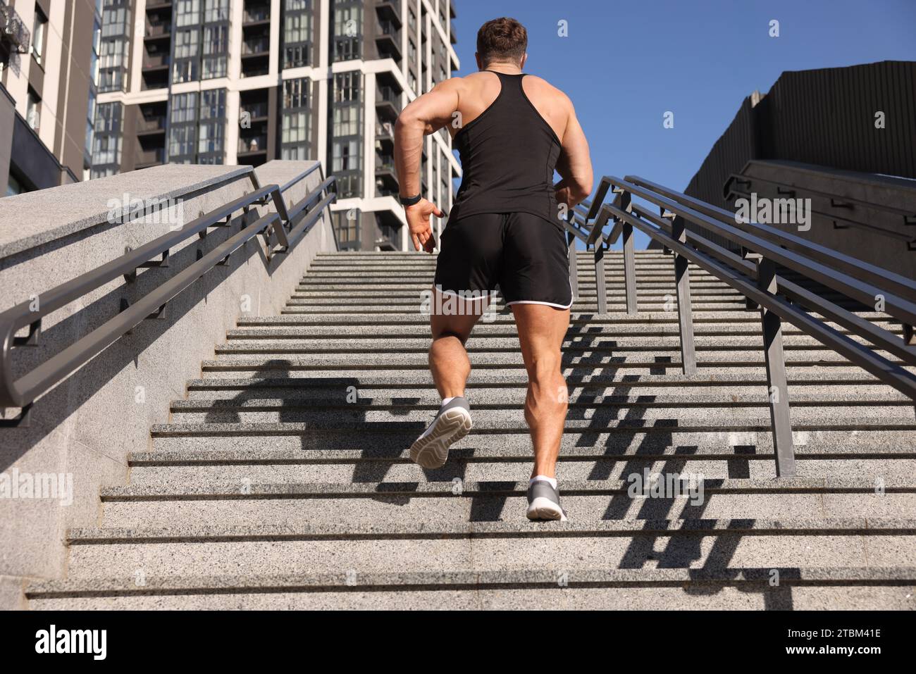 Man running up stairs outdoors on sunny day, back view Stock Photo - Alamy