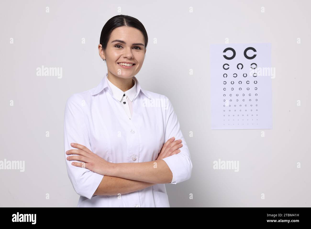 Ophthalmologist near vision test chart on white wall Stock Photo - Alamy