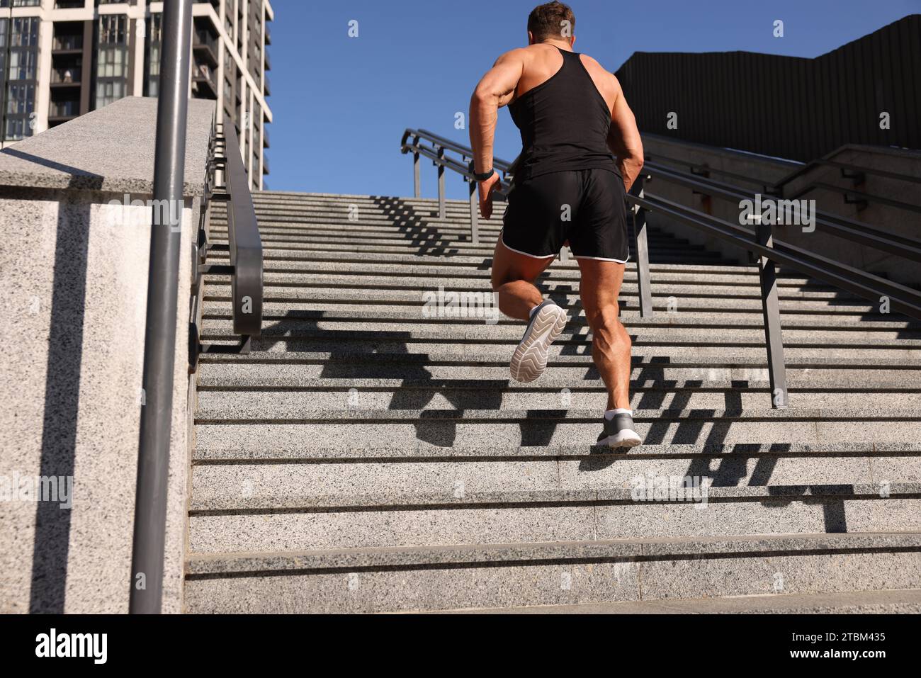 Man running up stairs outdoors on sunny day, back view Stock Photo - Alamy