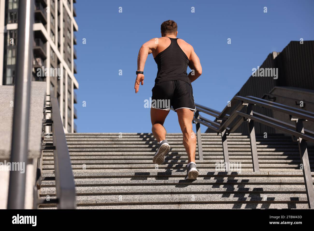 Man running up stairs outdoors on sunny day, back view Stock Photo - Alamy