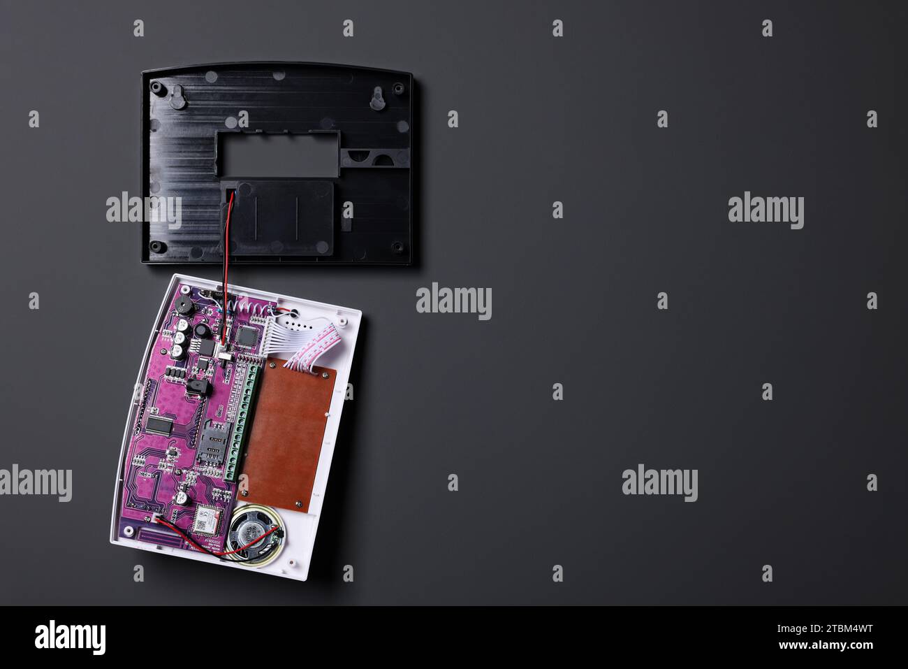 Installation of alarm system. Panel with circuit board on gray wall ...