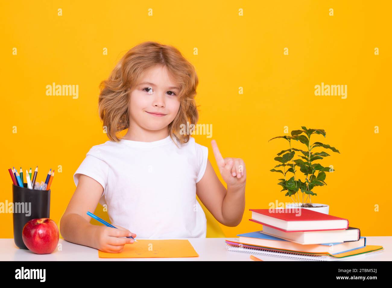 School kid holding index finger up with great new idea. School kid ...
